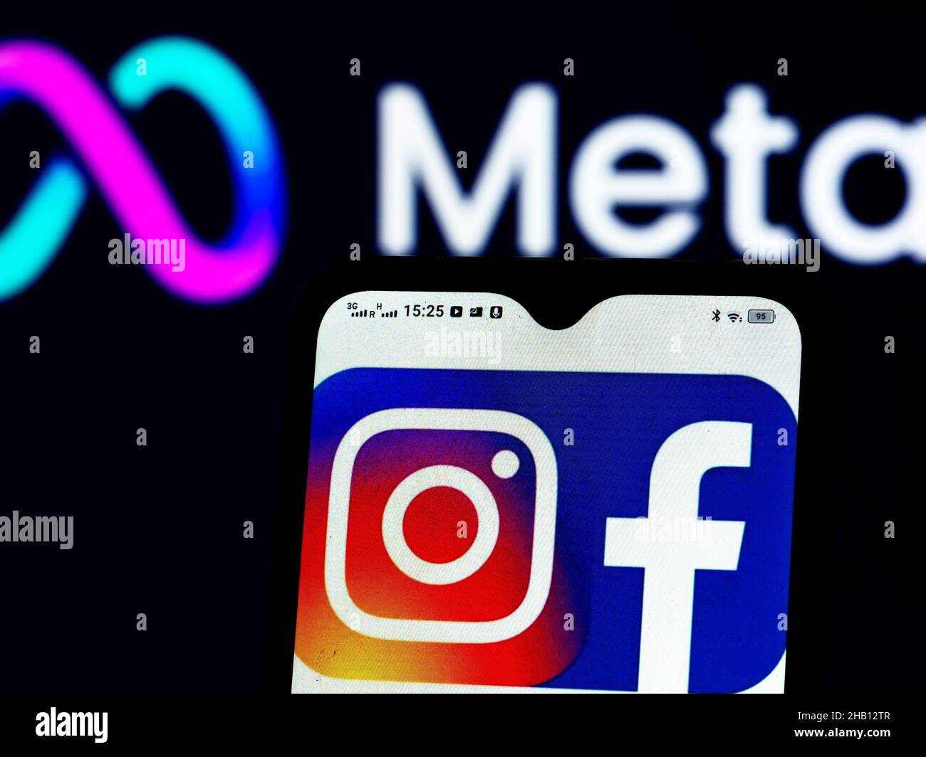 In this photo illustration Facebook and Instagram logos seen displayed on a smartphone and Meta ...