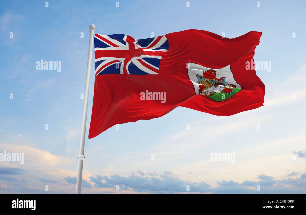 official flag of Bermuda at cloudy sky background on sunset, panoramic ...