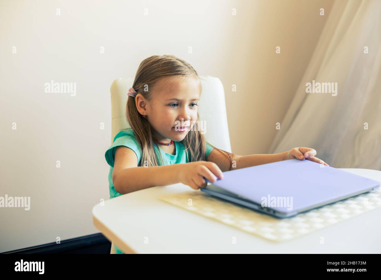 Little cute girl opens laptop to have video call Stock Photo - Alamy