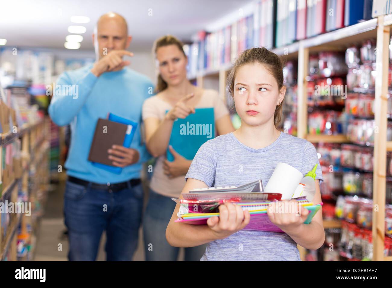 Girl berated by parents in school accessories store Stock Photo - Alamy