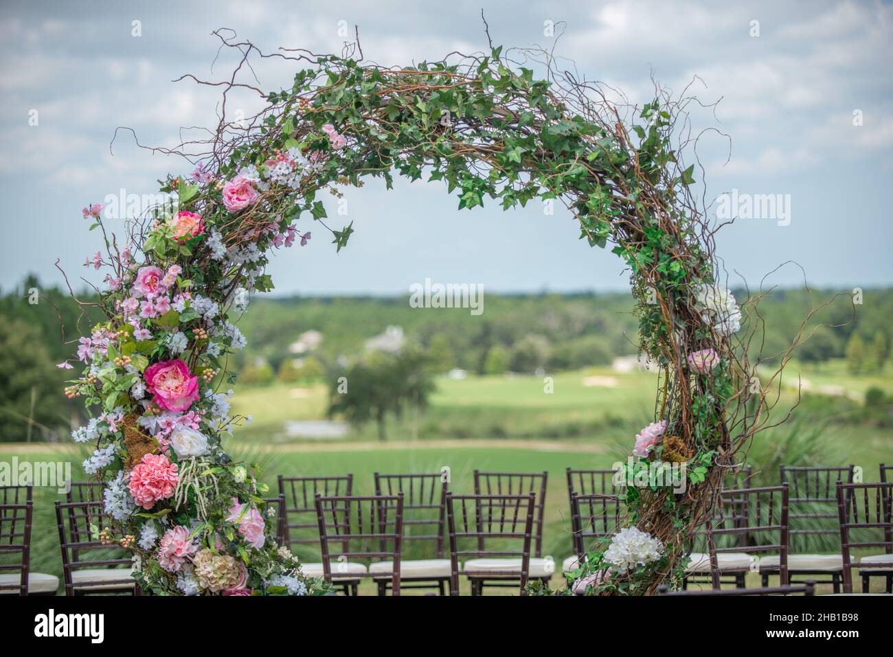 Huge round flower altar at wedding ceremony setting with brown chiavari ...