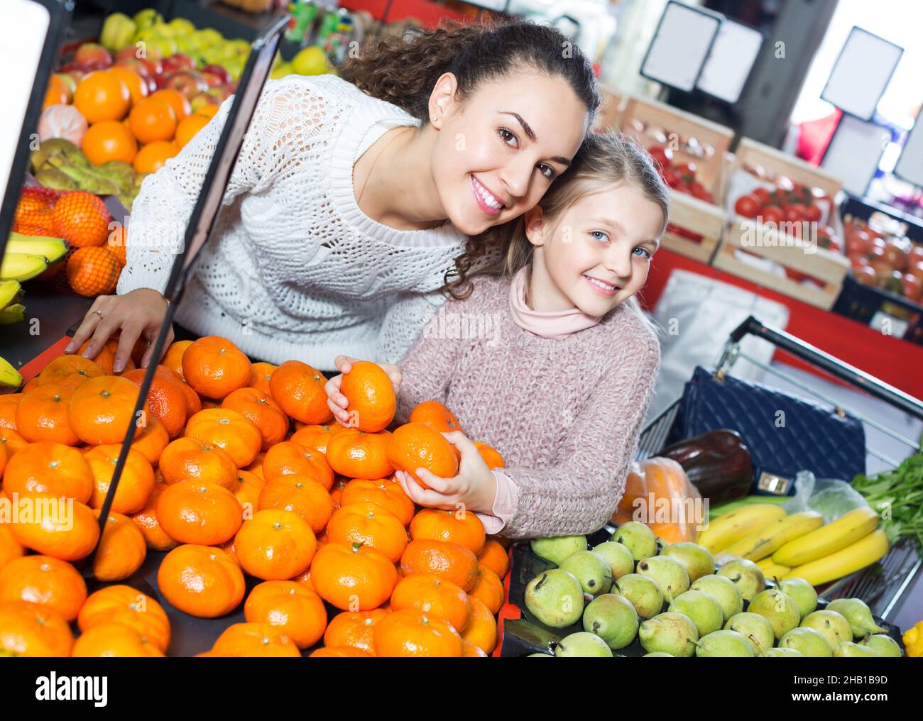 Woman and daughter purchasing fruits Stock Photo - Alamy