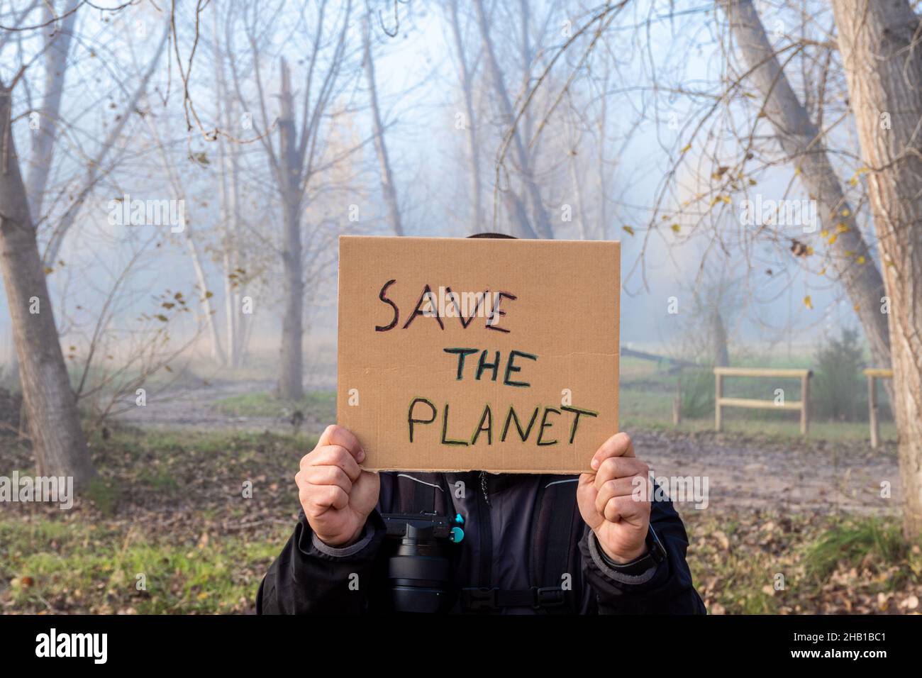 Male hands hold a cardboard sign with the slogan Save the Planet with ...