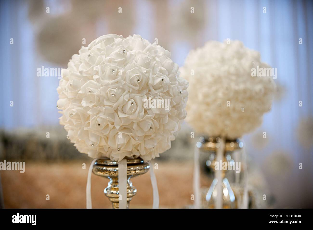 Gold table centerpieces with white ball flowers with diamonds at ...