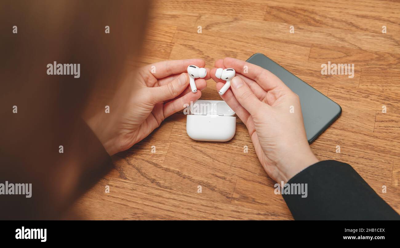 Overhead view of woman holding after unboxing new AirPods Pro wireless ...