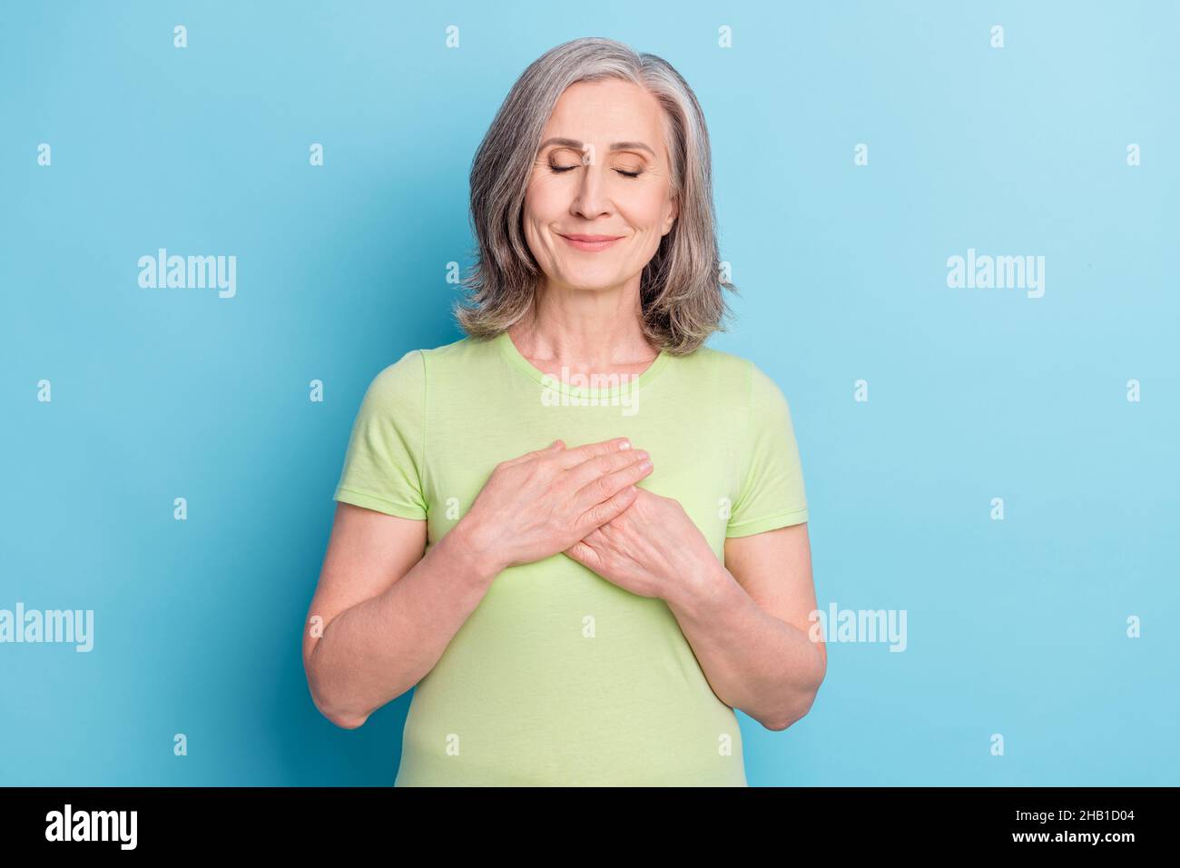 Photo of calm joyful happy woman hold hands chest heart good mood ...
