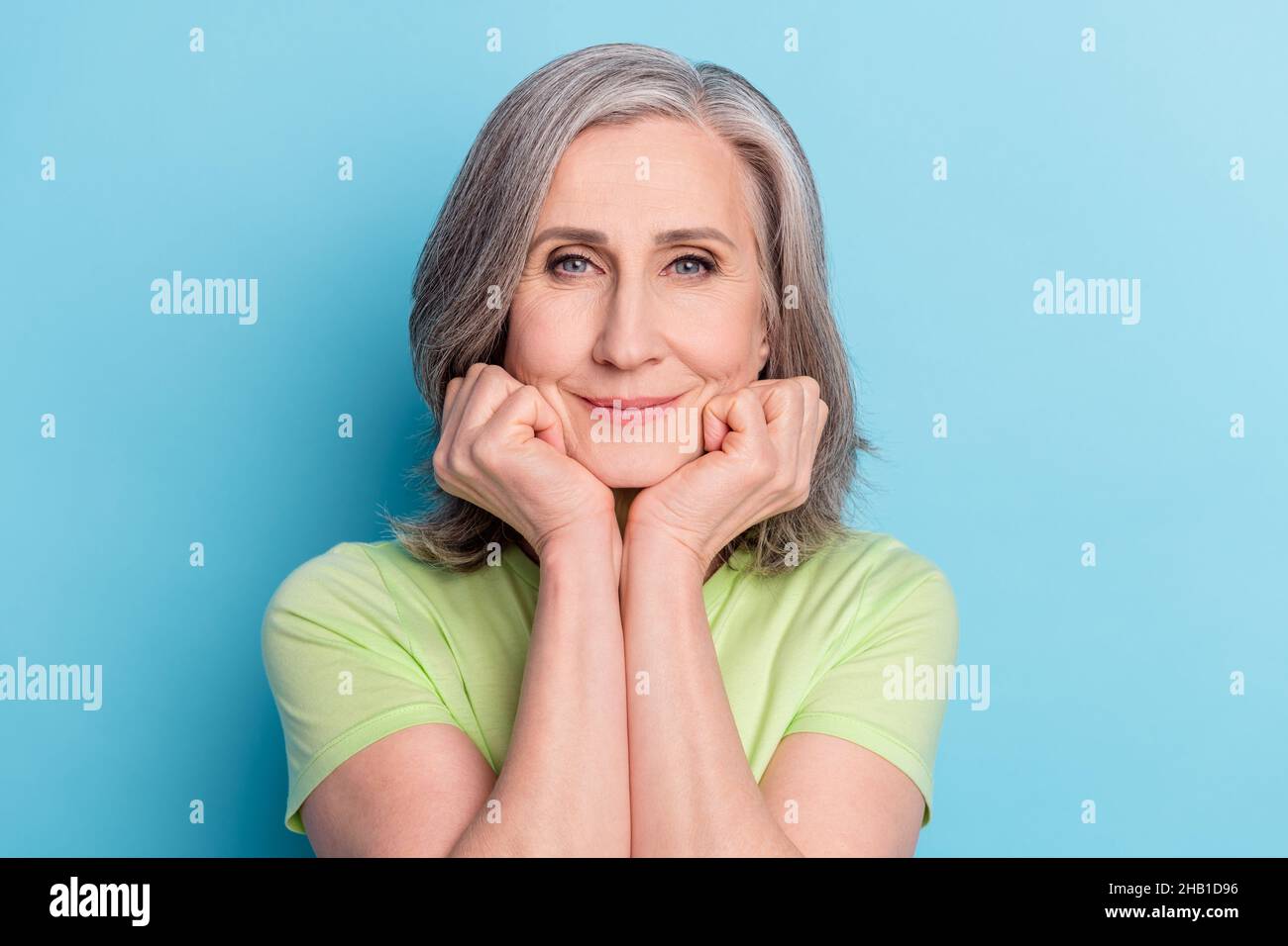 Photo of cheerful charming pretty old woman hold hands fists face ...