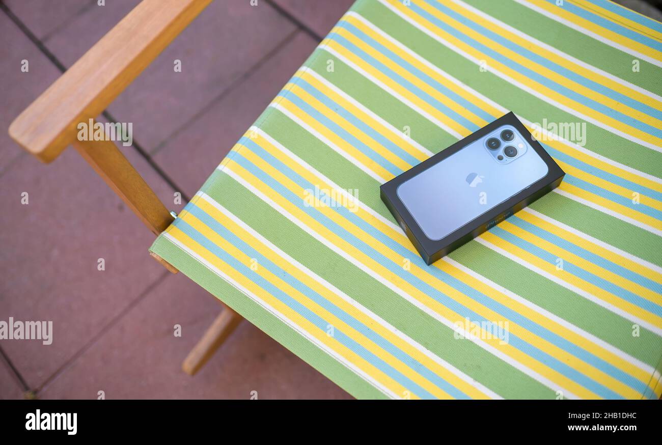 Terrace wooden chair with new cardboard package of iPhone 13 Pro Max 5G ...