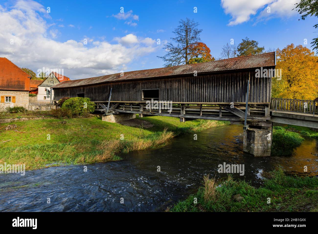 Roofed wooden bridge over the river Ilm in Buchfart, Thuringia, Germany ...