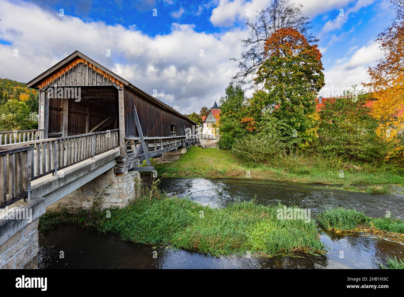 Roofed wooden bridge over the river Ilm in Buchfart, Thuringia, Germany ...