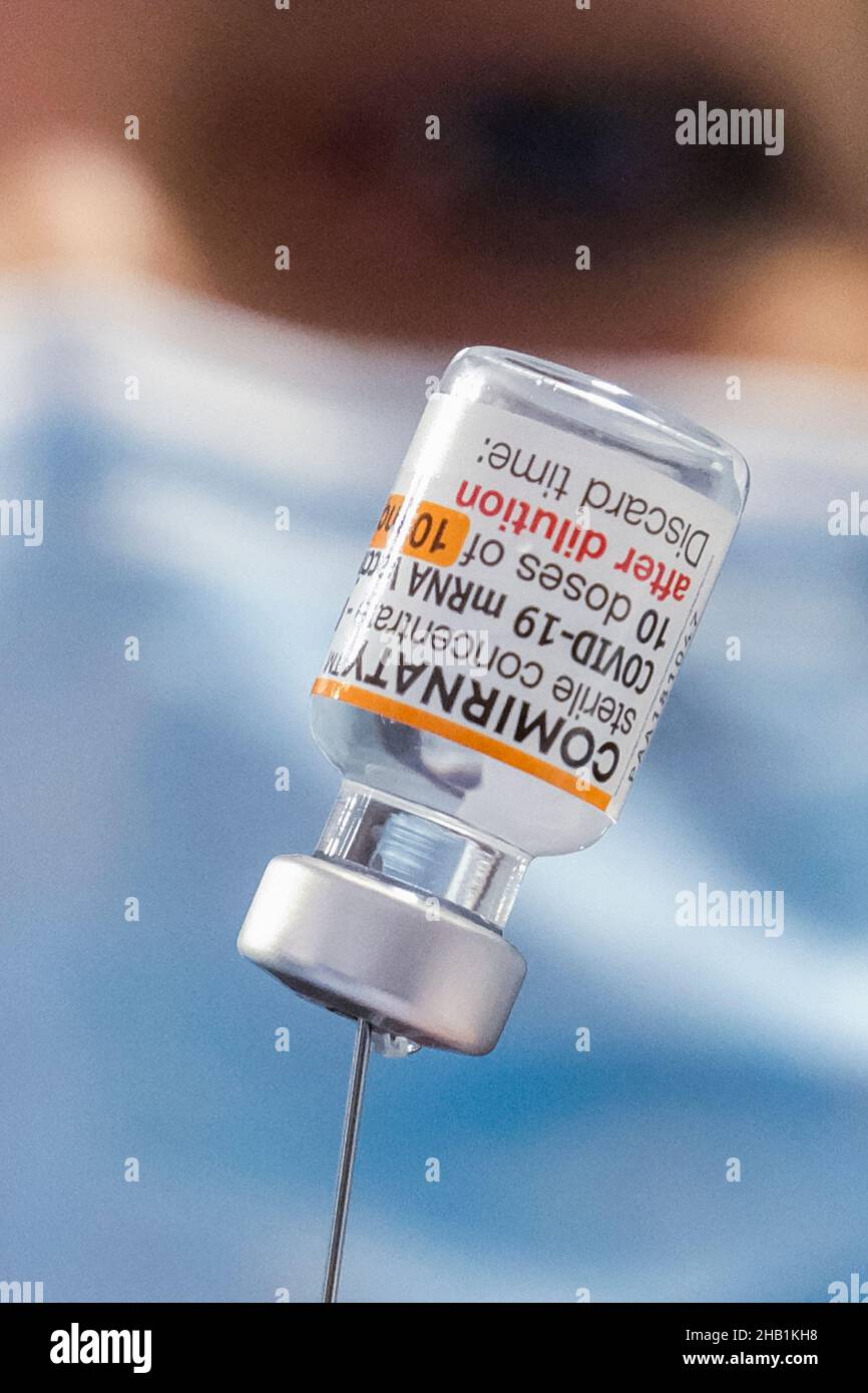 a doctor prepares a dose of pfizer comirnaty vaccine used to administer ...