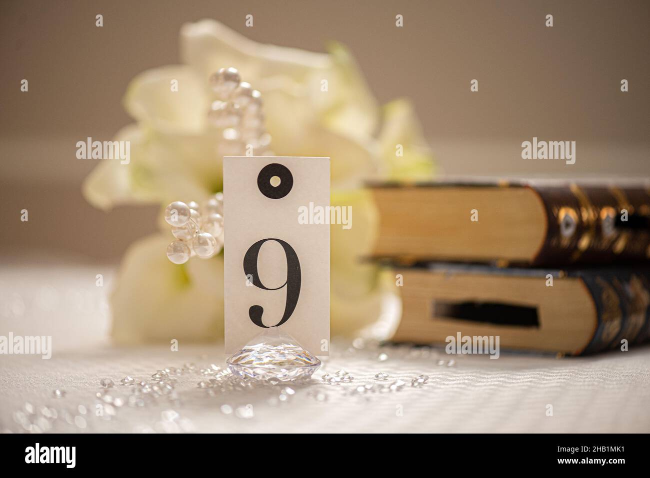 White number nine table place card in front of yellow flower on white ...