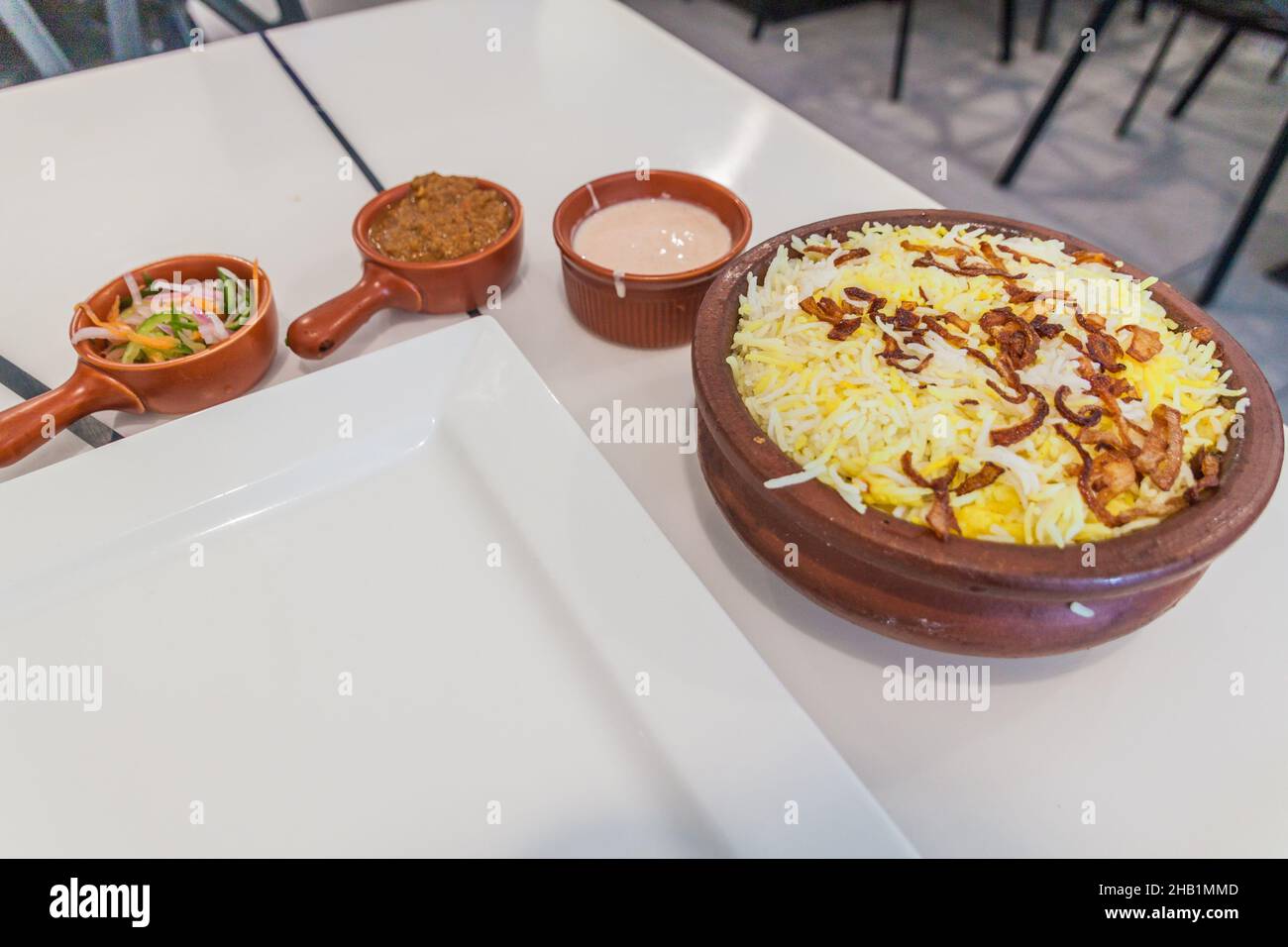 Biryani dish with several condiments Stock Photo - Alamy