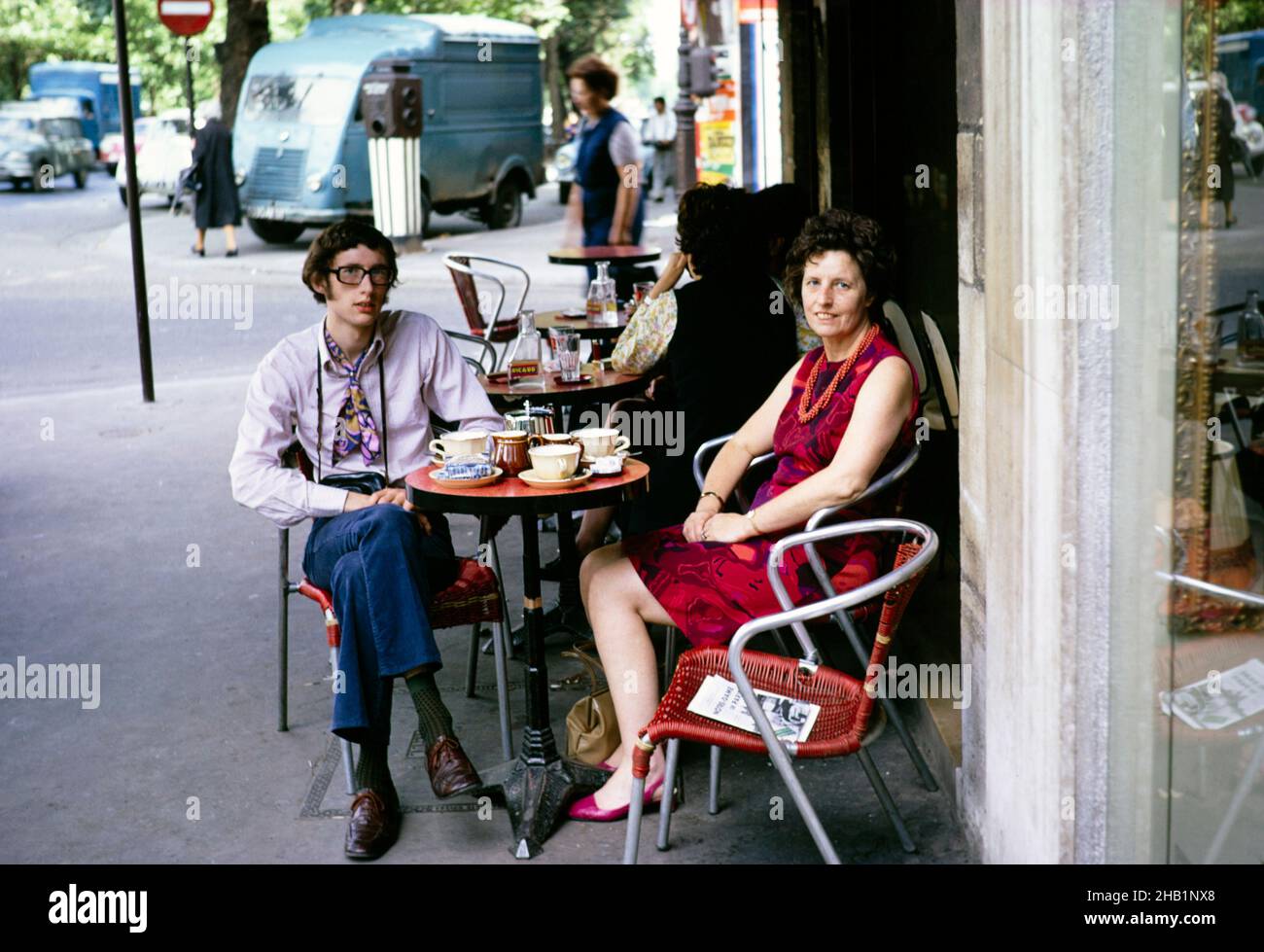 People sitting outside at street cafe table, city centre of Paris ...