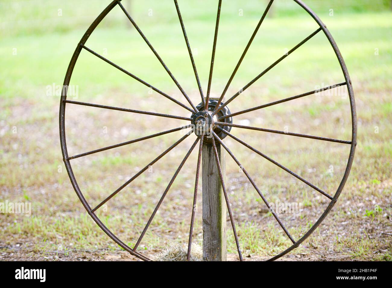 Old rusted wagon wheel rim spoke attached to wood as yard decor Stock ...