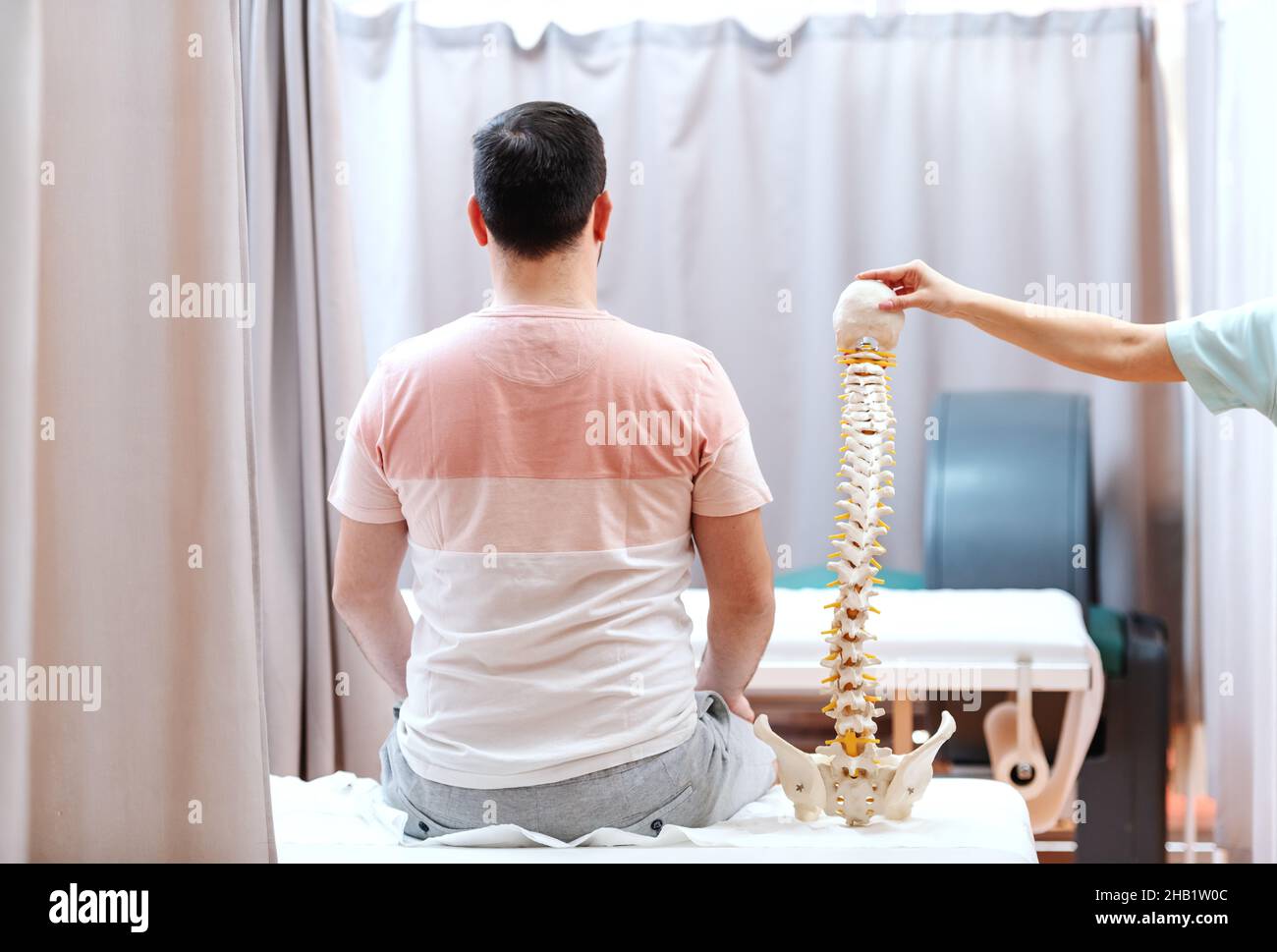 Man sitting on hospital bed with backs turned. Next to him doctor ...