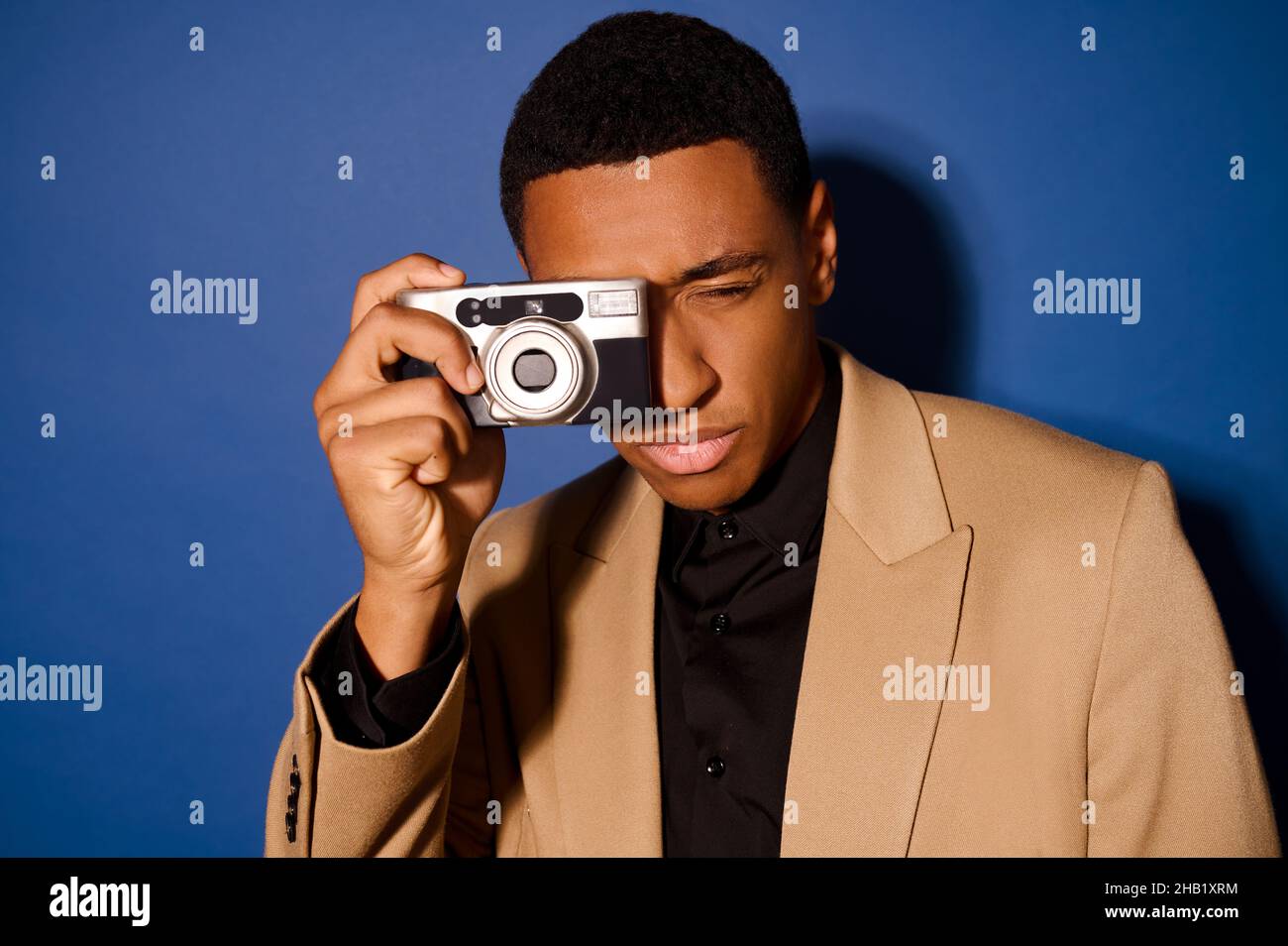Guy with closed eye holding camera near face Stock Photo - Alamy
