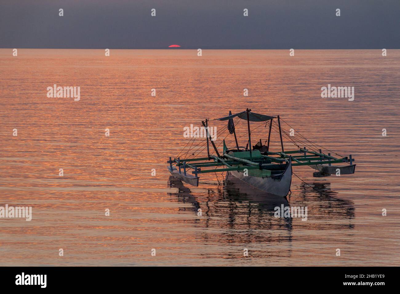 Sunset view of a bangka double-outrigger boat on Siquijor island ...