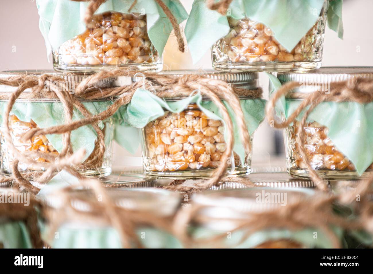 Popcorn kernels stacked in glass jars with green tops at dessert bar ...