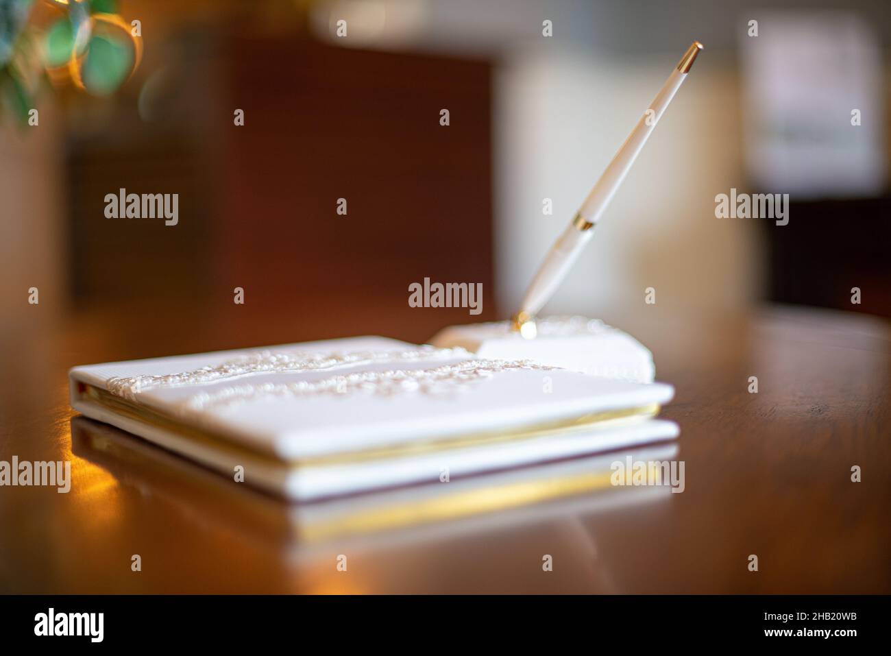 White signing pen in white pen stand on shiny wood table near sign in ...