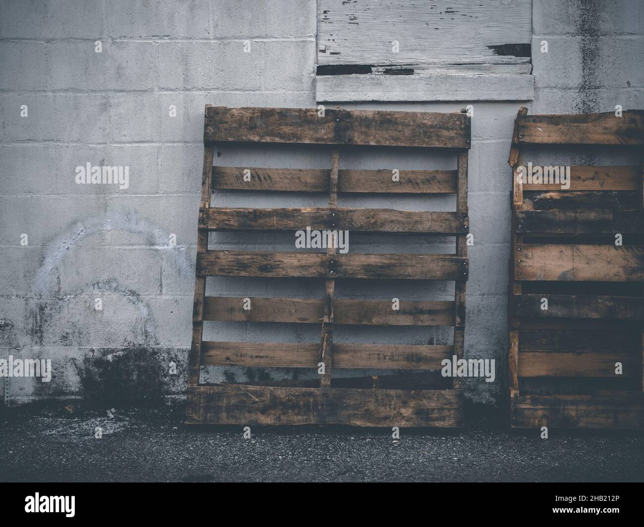 Rusty wooden pallets against a weathered wall Stock Photo - Alamy
