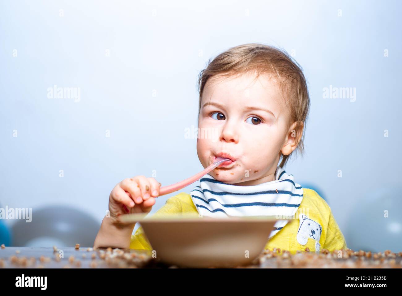 Baby eating kids food. Funny kid boy with plate and spoon Stock Photo ...