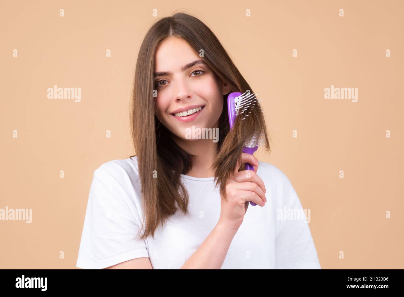 Attractive woman combing hair. Beautiful girl combs hair. Haircare ...