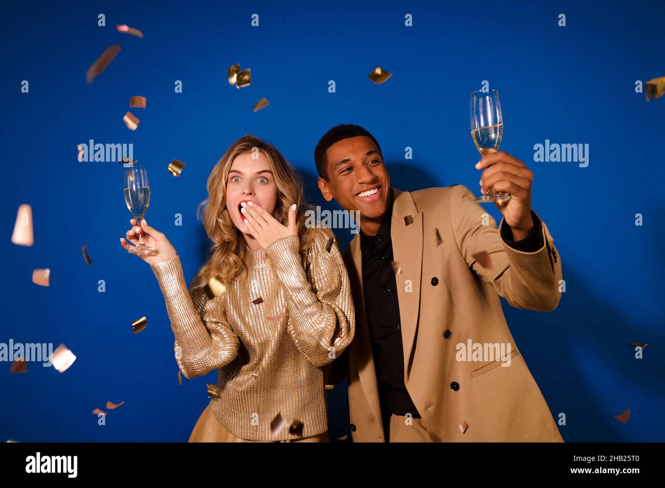 Surprised girl and smiling guy with champagne and flying confetti Stock ...