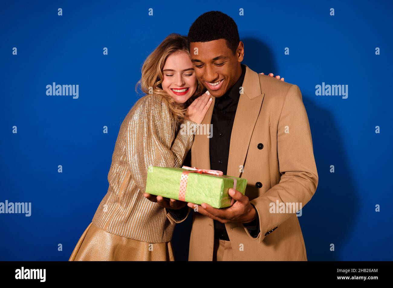 Girl hugging happy guy with gift Stock Photo - Alamy