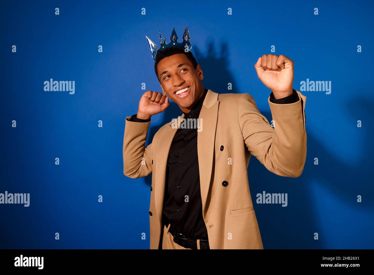 Joyful guy in crown looking to side Stock Photo - Alamy