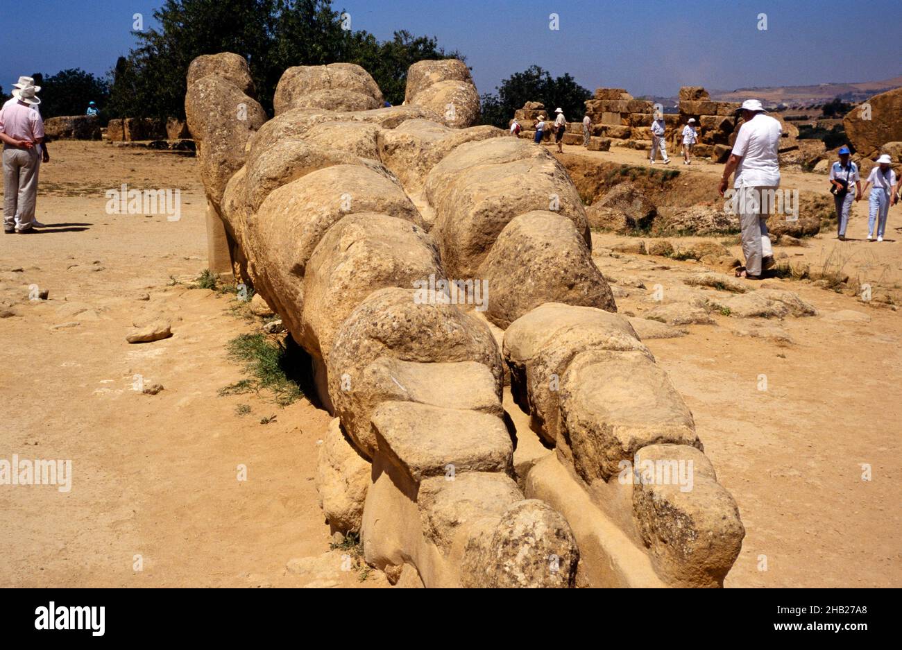 Tourists sightseeing Greek ruins giant statue Atlas or Telamon, temple ...