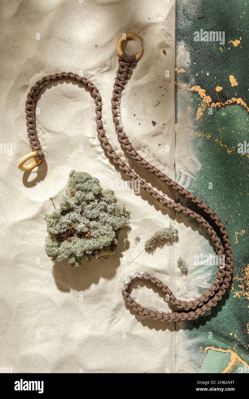 Unrolled moss green yoga mat, rope for stretching and dried moss on ...