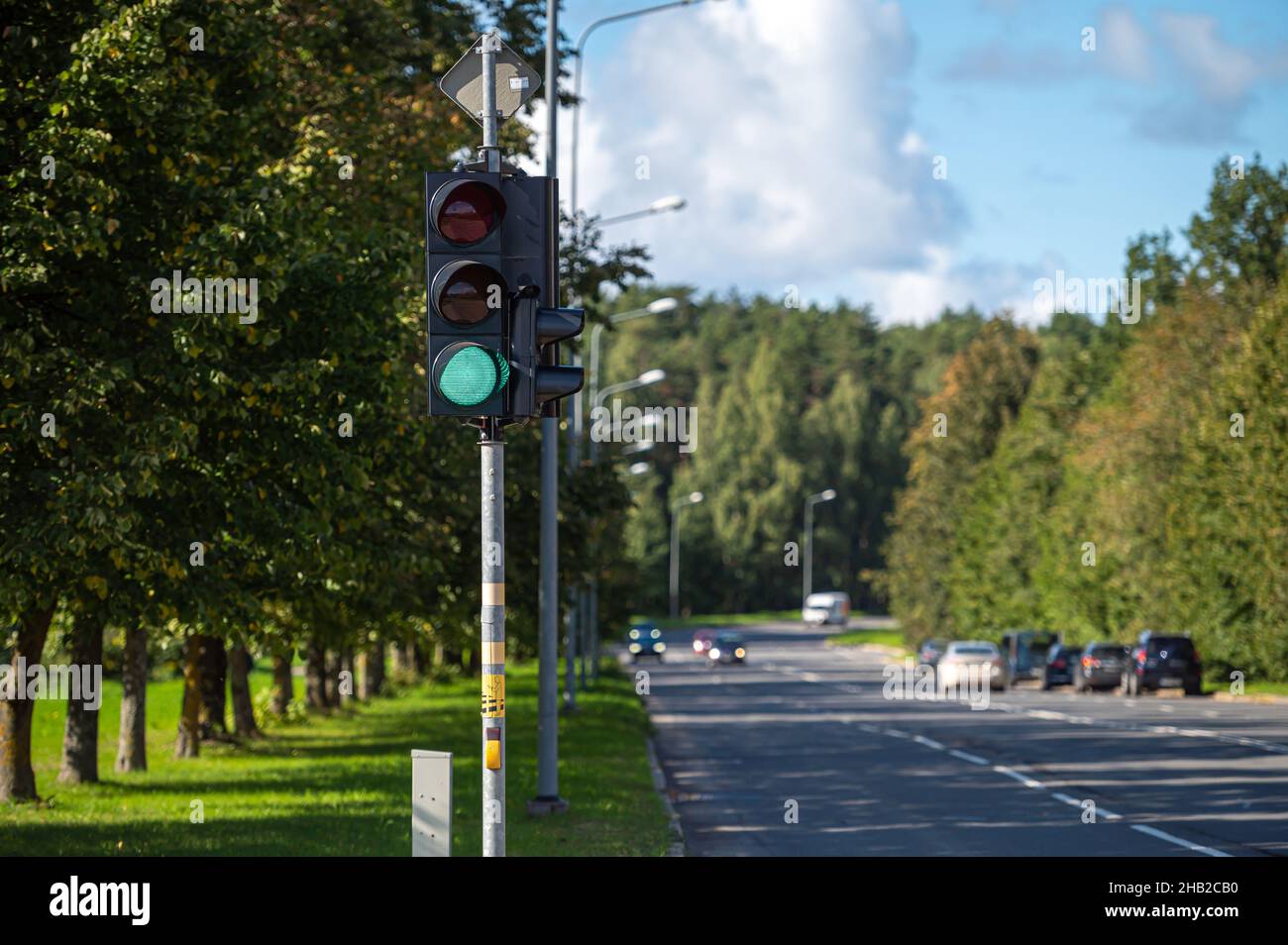 closeup of traffic semaphore with green light on defocused city street ...