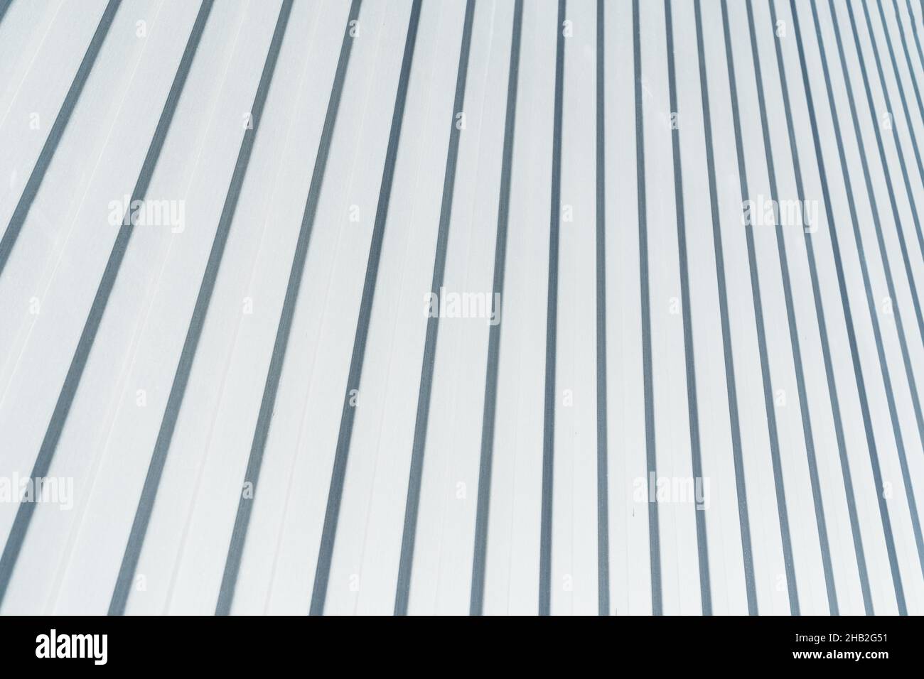 Metal siding with a corrugated pattern of white color diagonally ...
