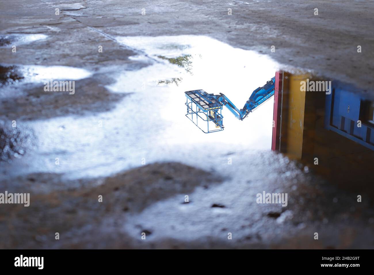Puddle reflections of a Mobile Eleveated Work Platform or boom lift ...