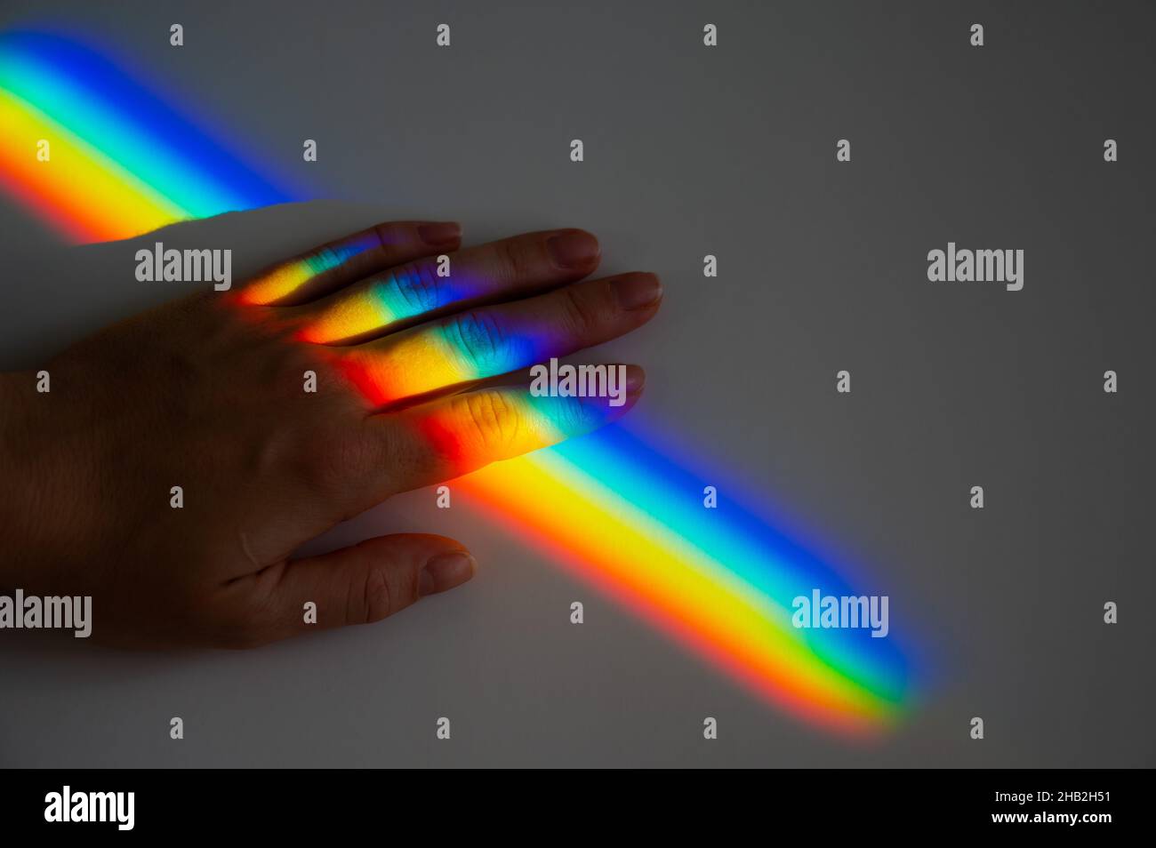Rainbow ray on a woman's hand Stock Photo - Alamy