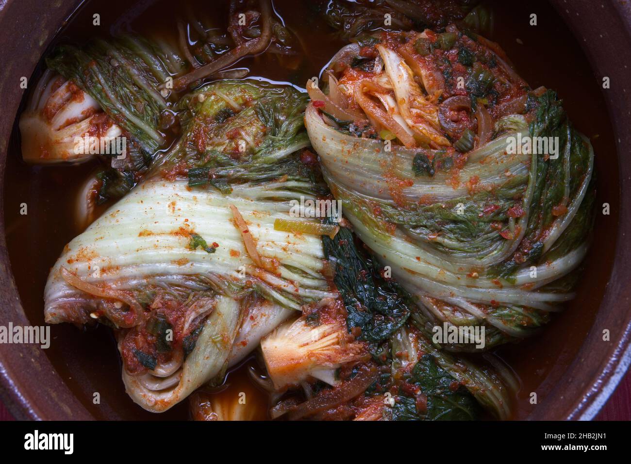 A studio overview of whole kimchi freshly made inside a large pot. A ...