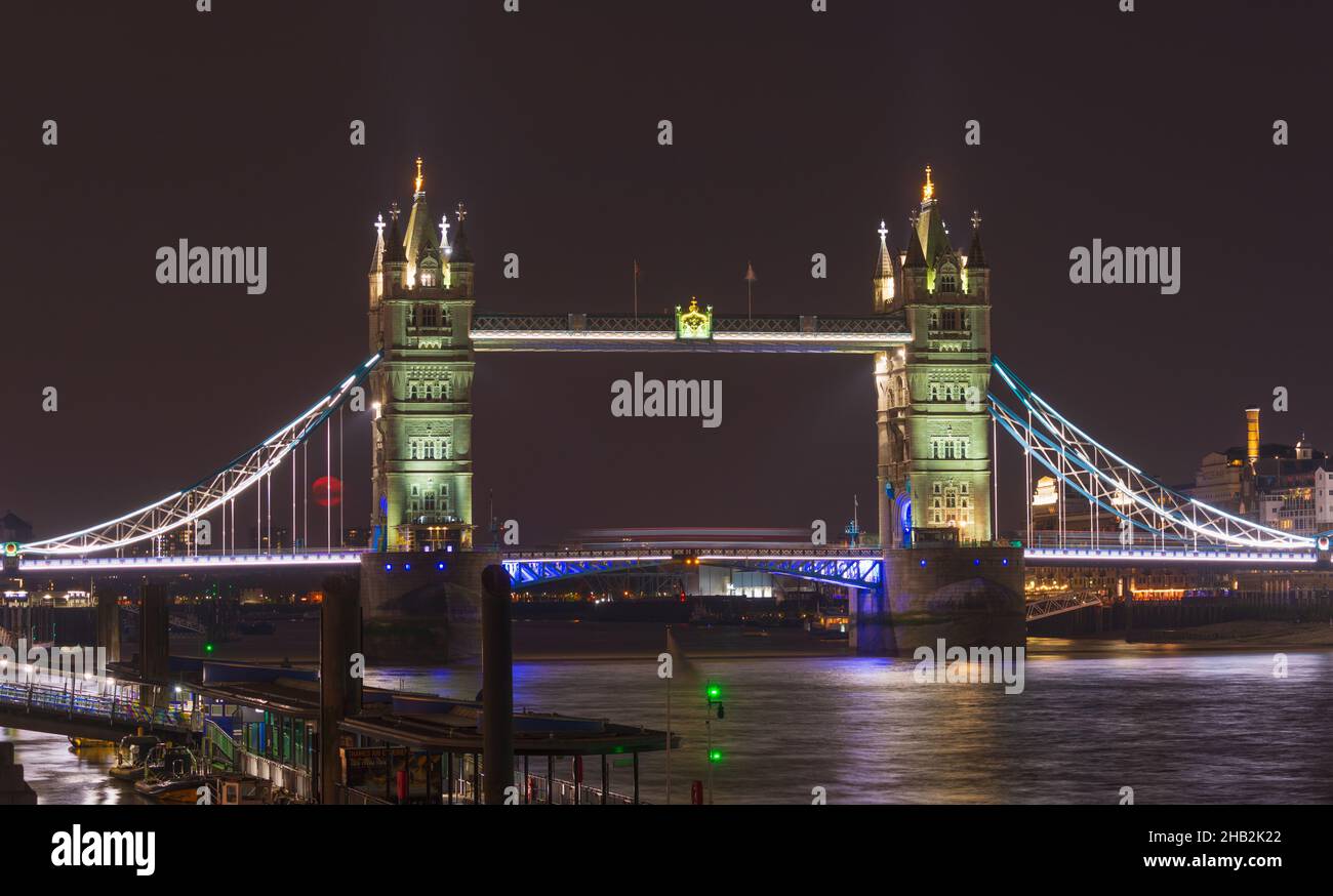 a night time view of a full moon rising behind the illuminated Tower ...