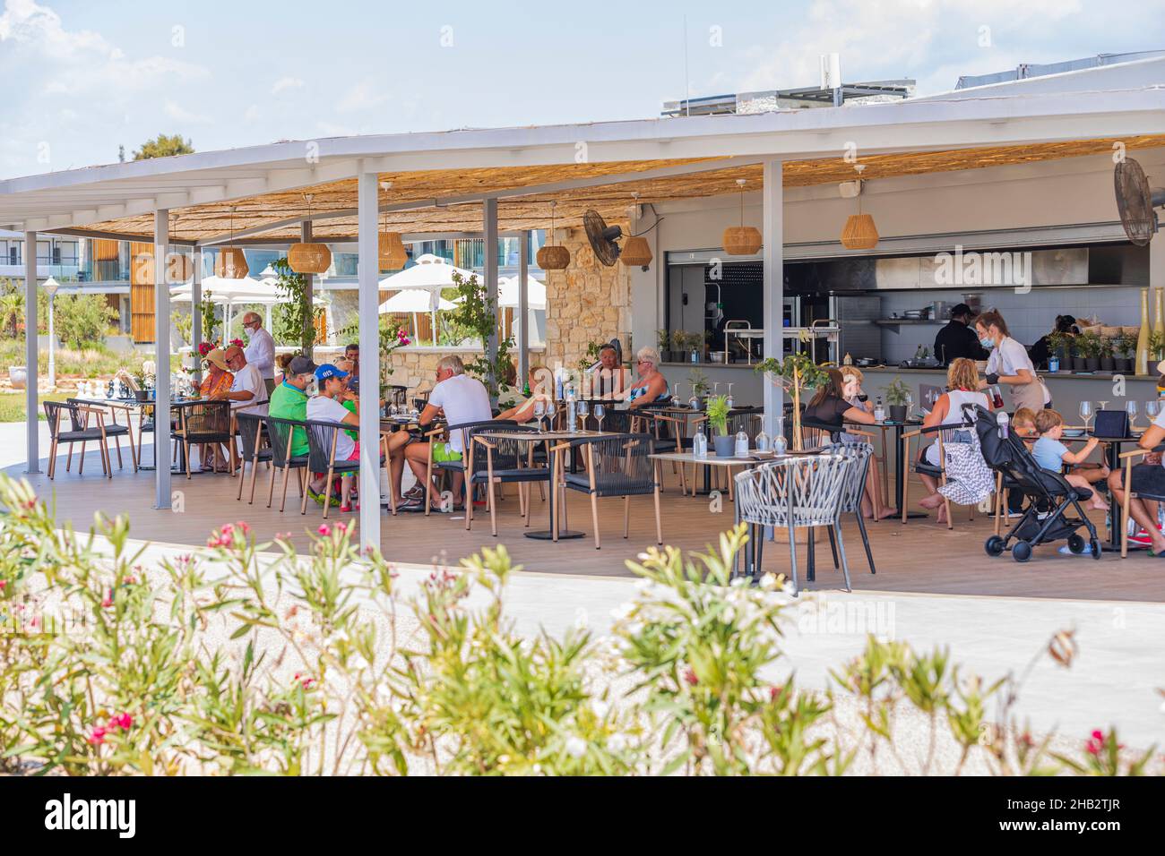 Beautiful view of people at hotel outdoor restaurant. Greece. Nea ...