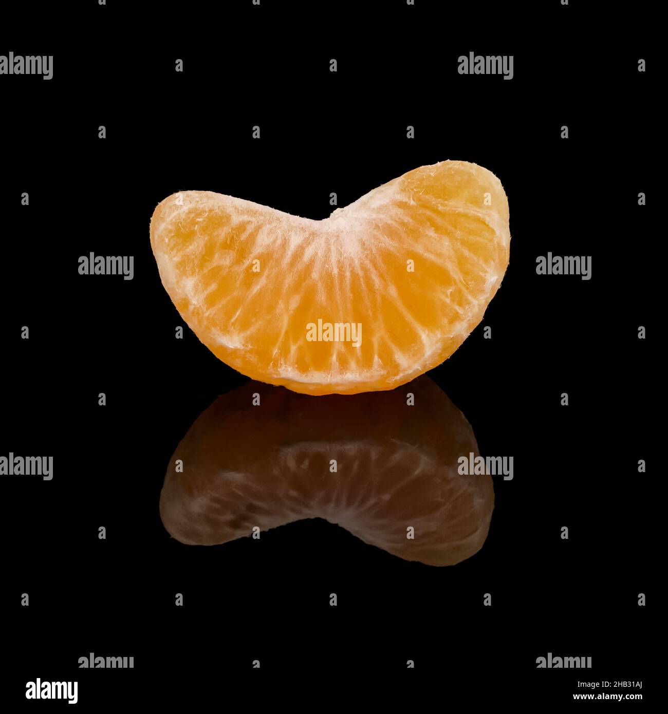 Slice of ripe tangerine, on a black background with reflection Stock ...