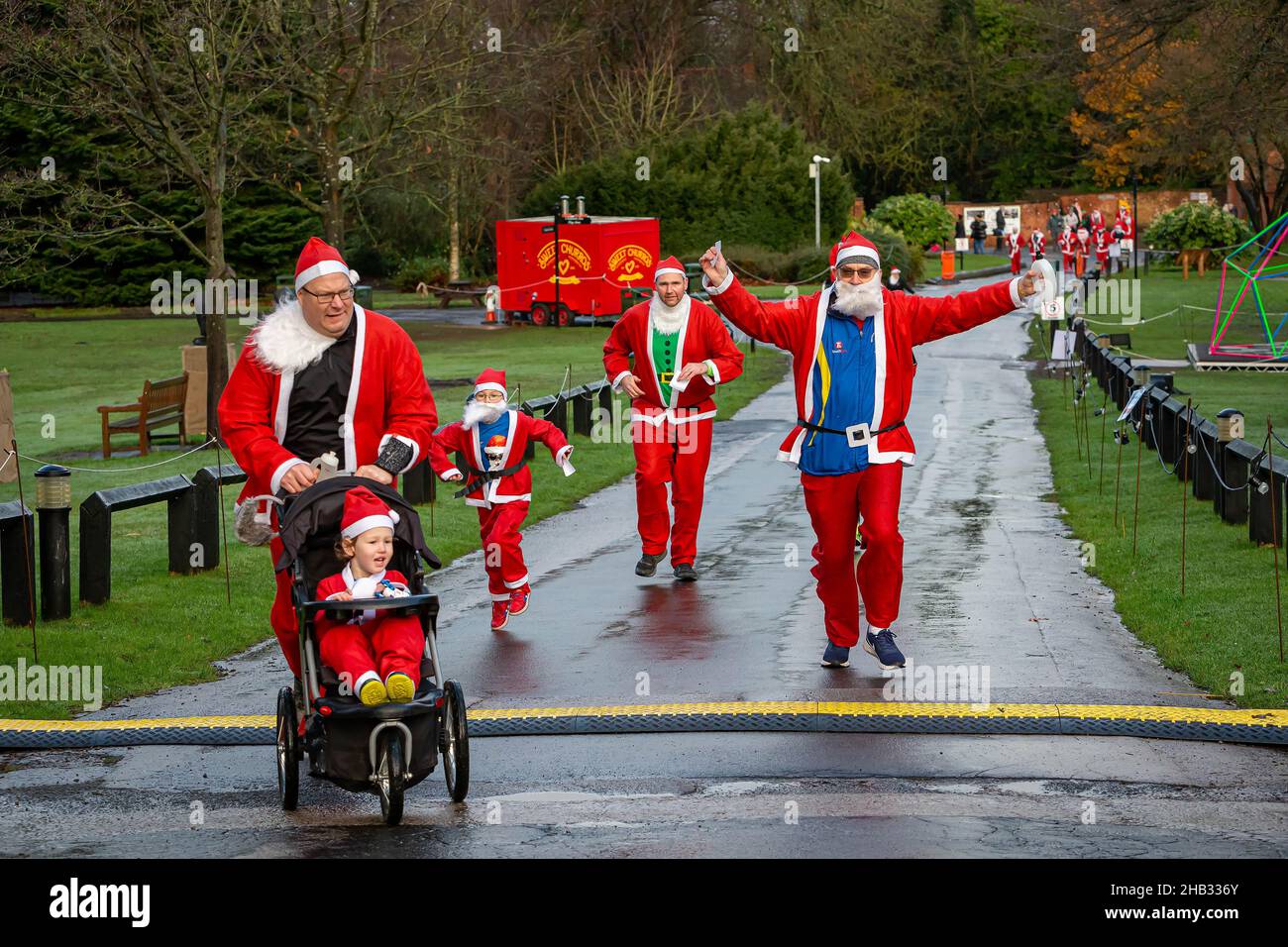 Santa holds his arms up whilst running up a hill in a Santa Dash Stock ...