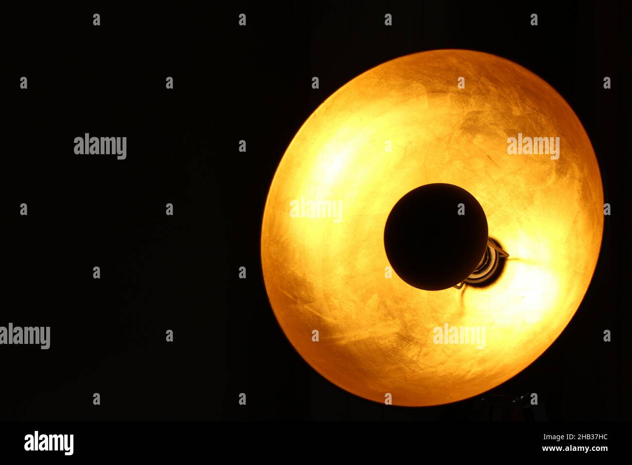 Warm golden lamp against a black background Stock Photo - Alamy