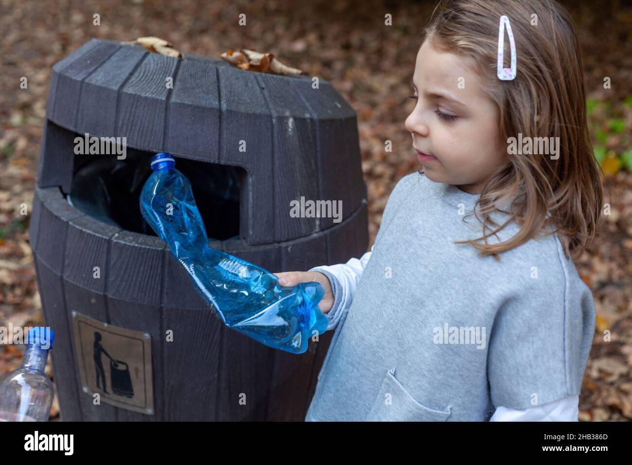 Young Caucasian girl throwing out the trash in a park Stock Photo - Alamy