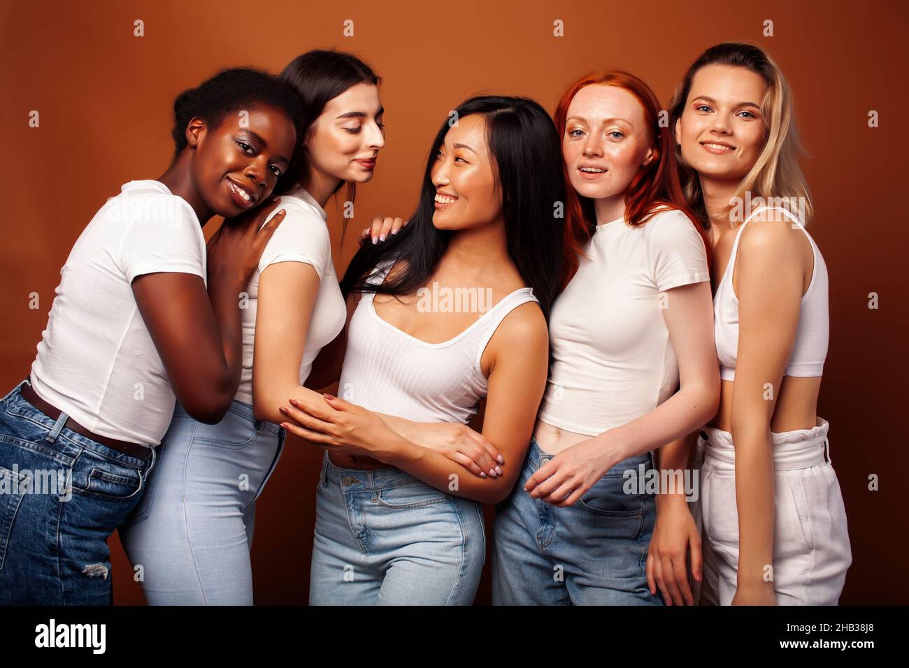 young pretty caucasian, afro, scandinavian woman posing cheerful together on brown background ...