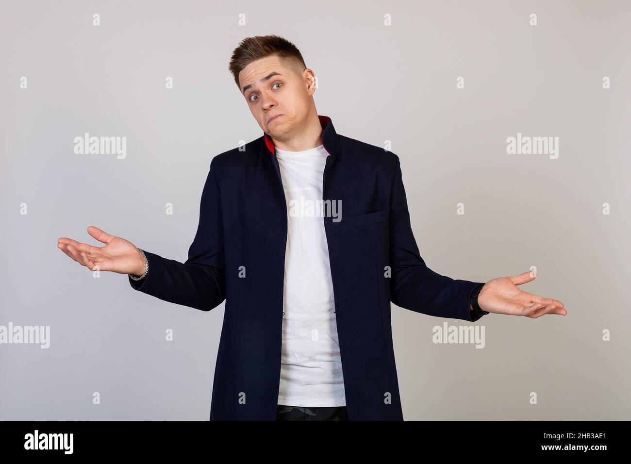 Male young man with a lost expression shrugs his shoulders. The guy ...