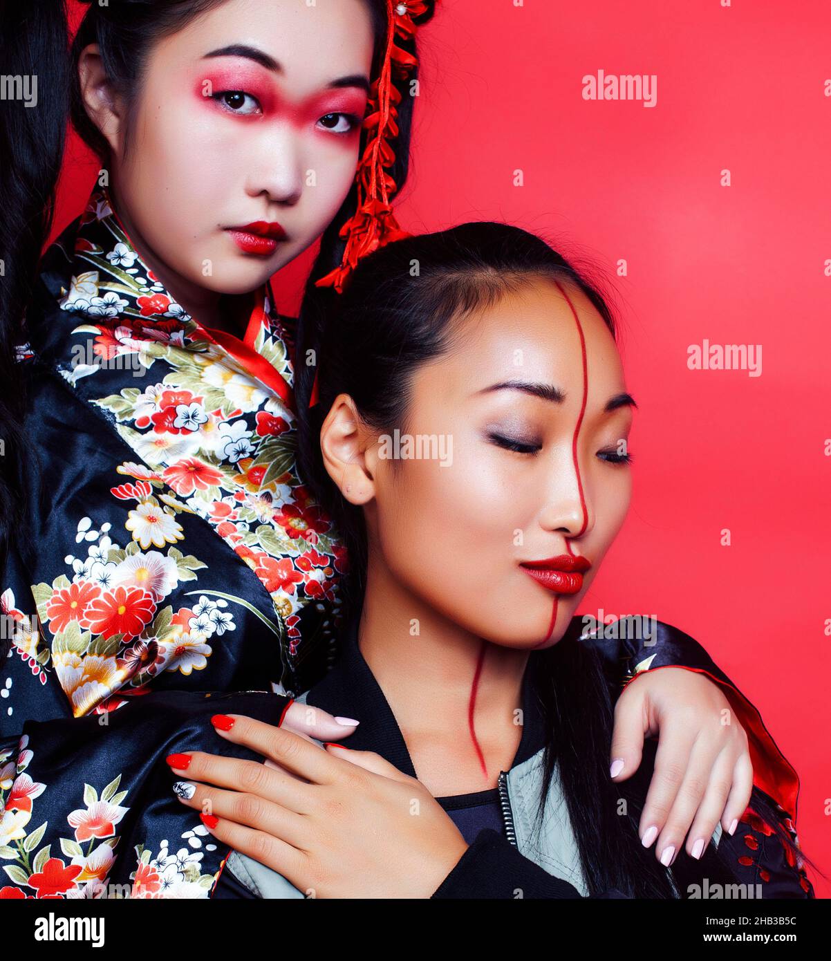 two pretty geisha friends: modern asian woman and traditional wearing ...