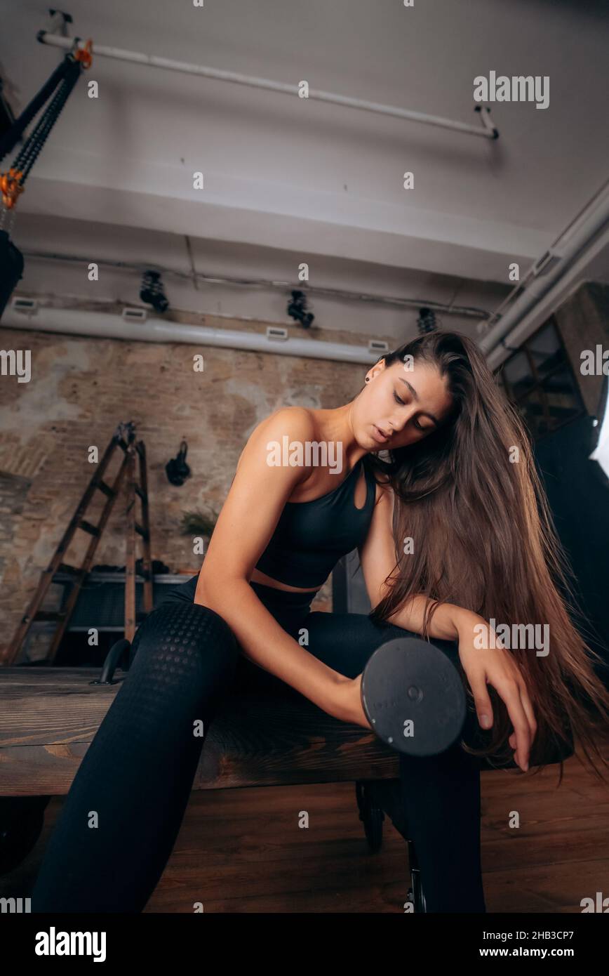 Young woman pumps up the muscles by one arm lifting dumbbell Stock ...