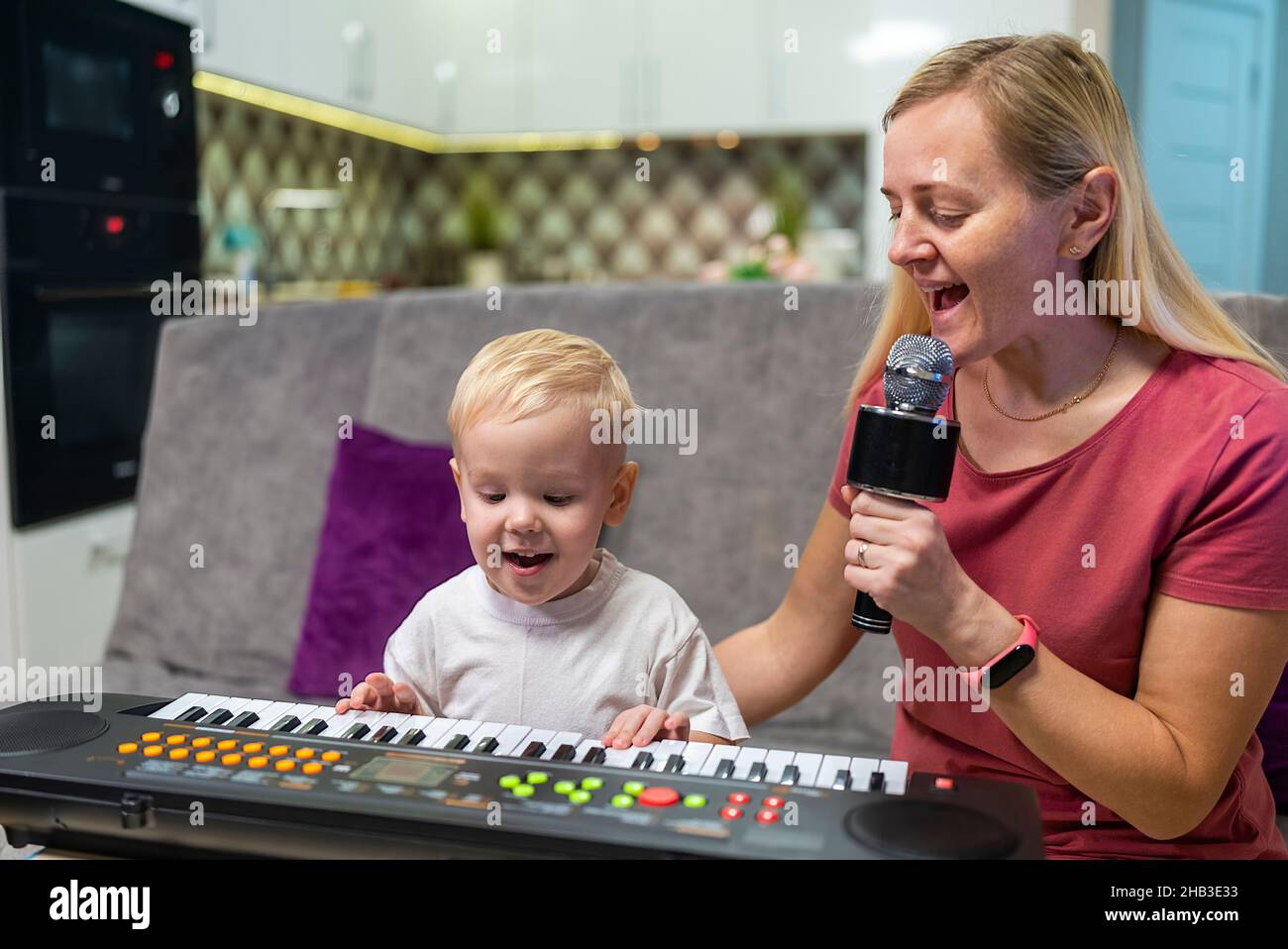 baby and mom learning to play the piano and sing at home Stock Photo ...