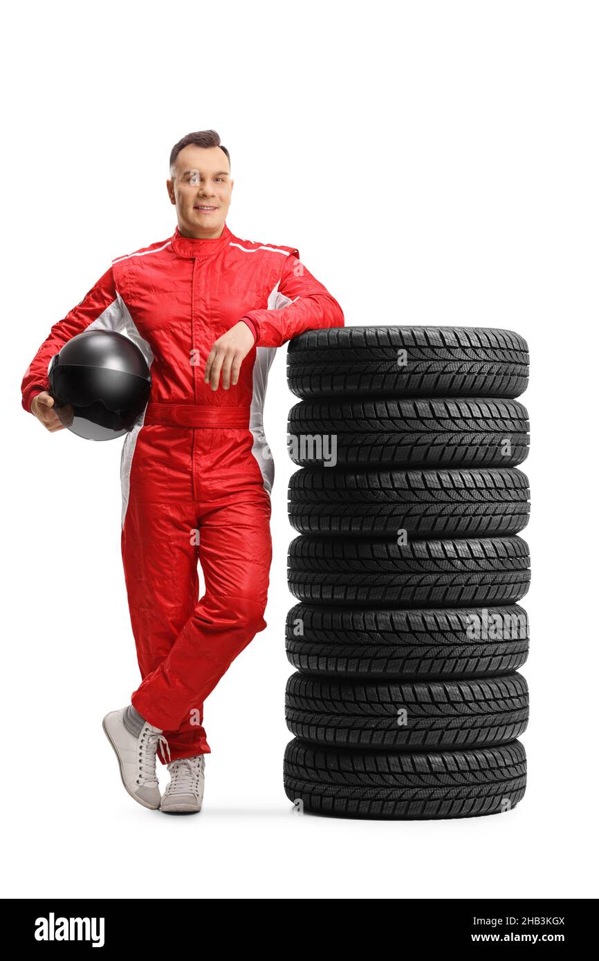 Full length portrait of a racer in a red suit leaning on a pile of ...