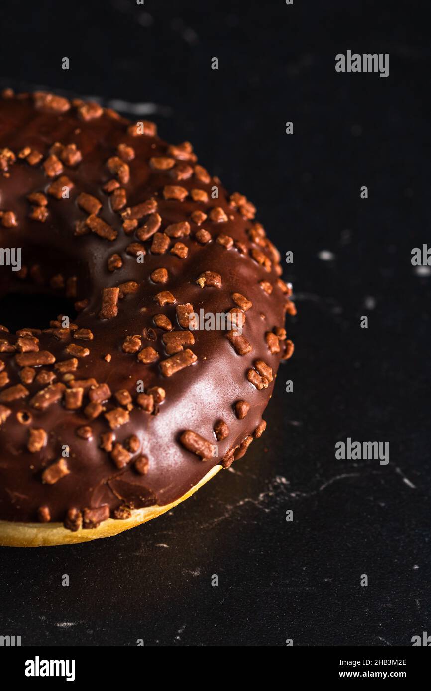 Vertical closeup of a delicious chocolate glazed donut isolated on a ...